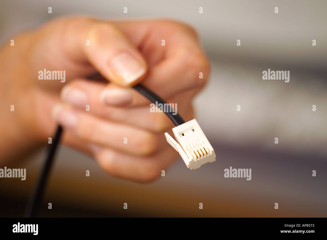 Hand holding telephone cable with plug Stock Photo - Alamy