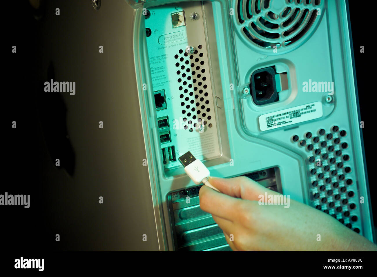 Hand plugging in USB plug into back of a computer Stock Photo - Alamy