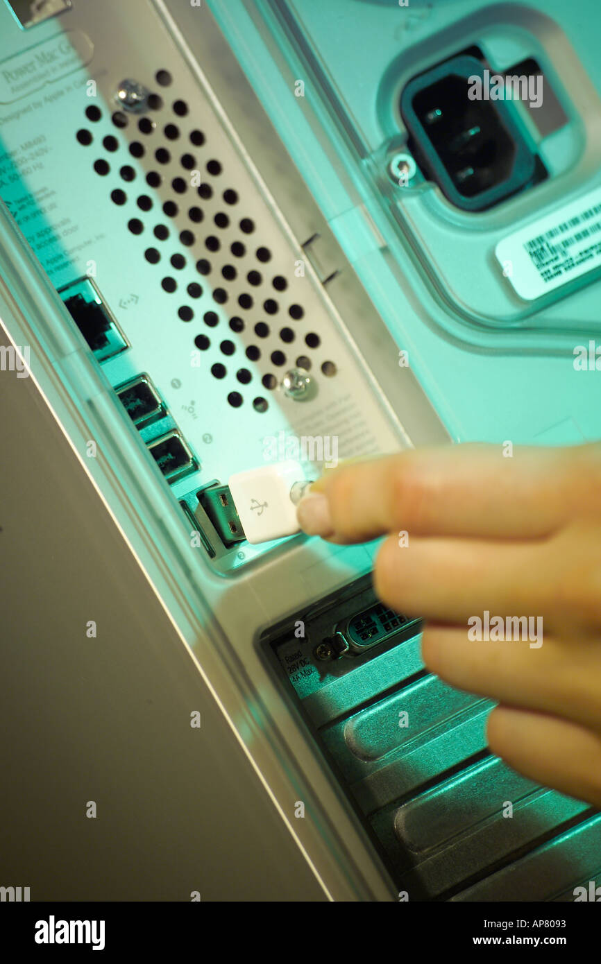Hand plugging in USB plug into back of a computer Stock Photo - Alamy