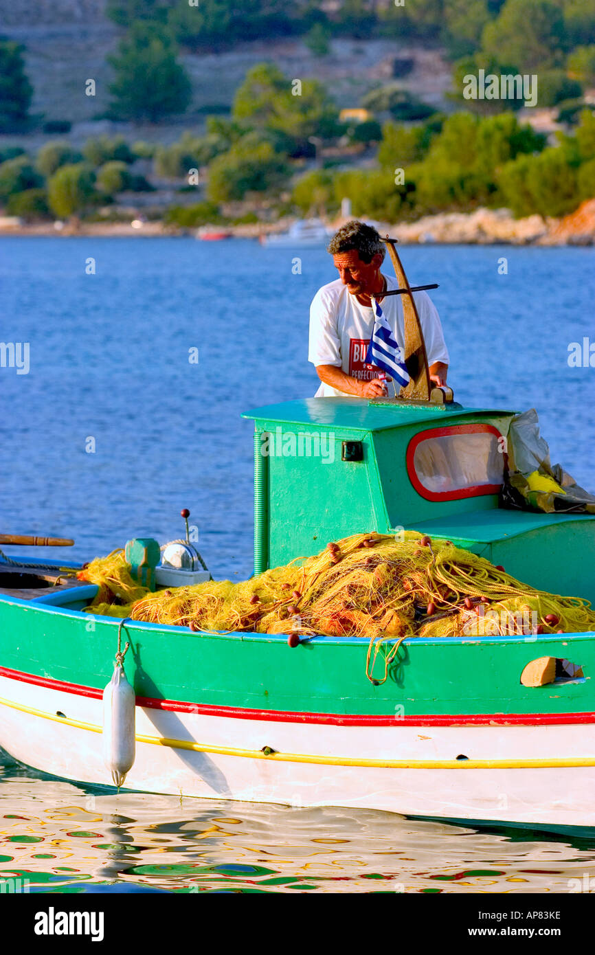fishing rowing with fisher man inside preparing fishnet in symi ...
