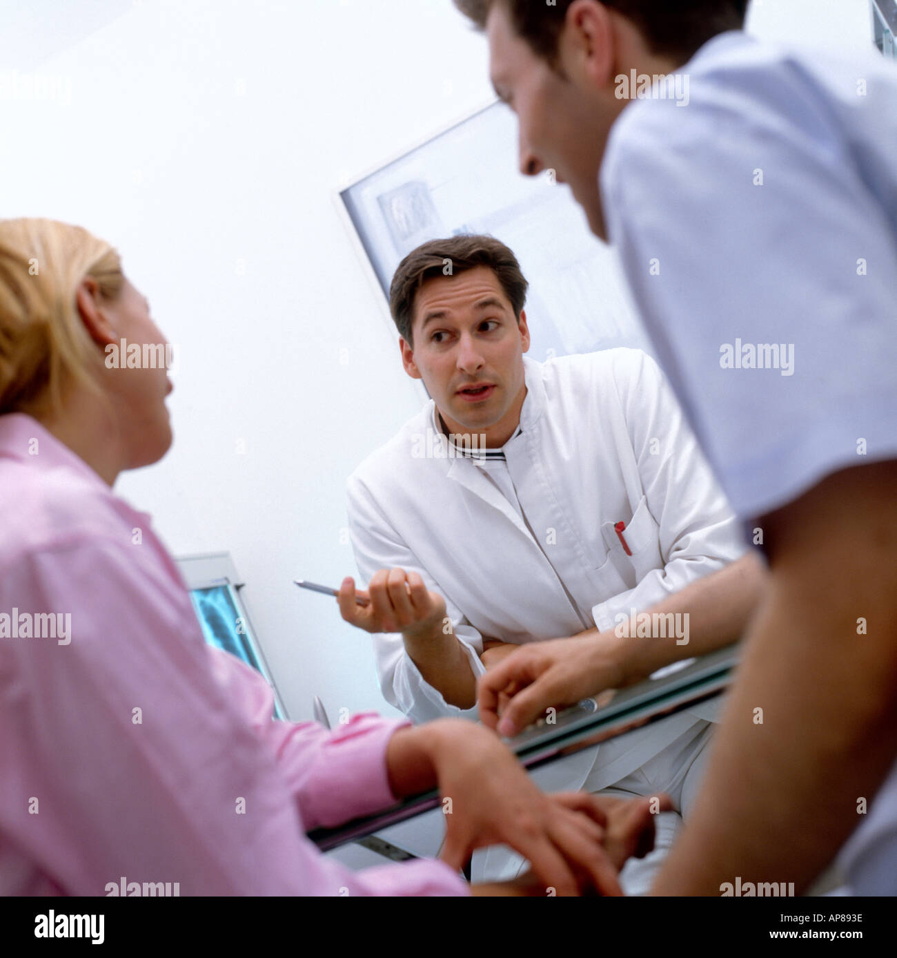 Doctor advising couple hi-res stock photography and images - Alamy