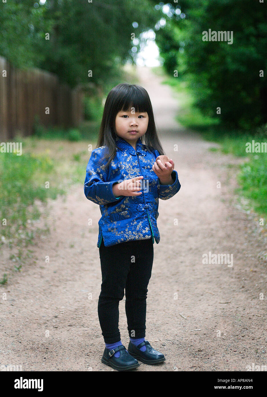 little chinese girl holding a rock wearing traditional chinese clothes ...