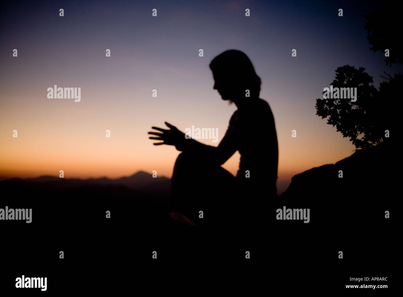 Very colorful sunset with silhouette of woman that can be thinking ...
