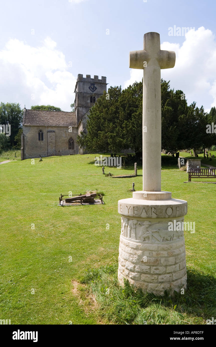 The Millennium cross in the churchyard of Holy Cross church in the Cotswold village of Avening ...