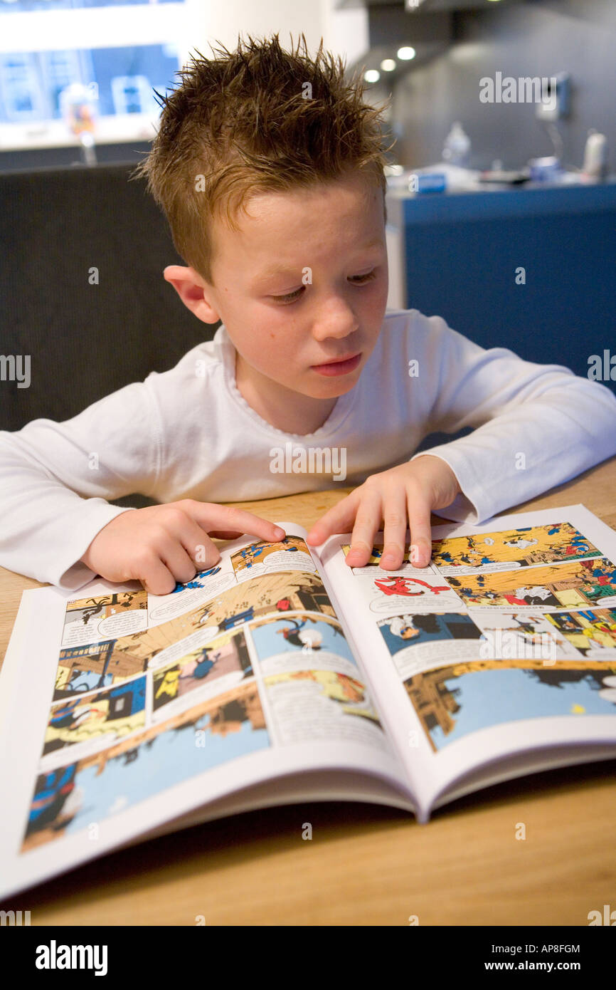 Boy is reading a comic Stock Photo - Alamy