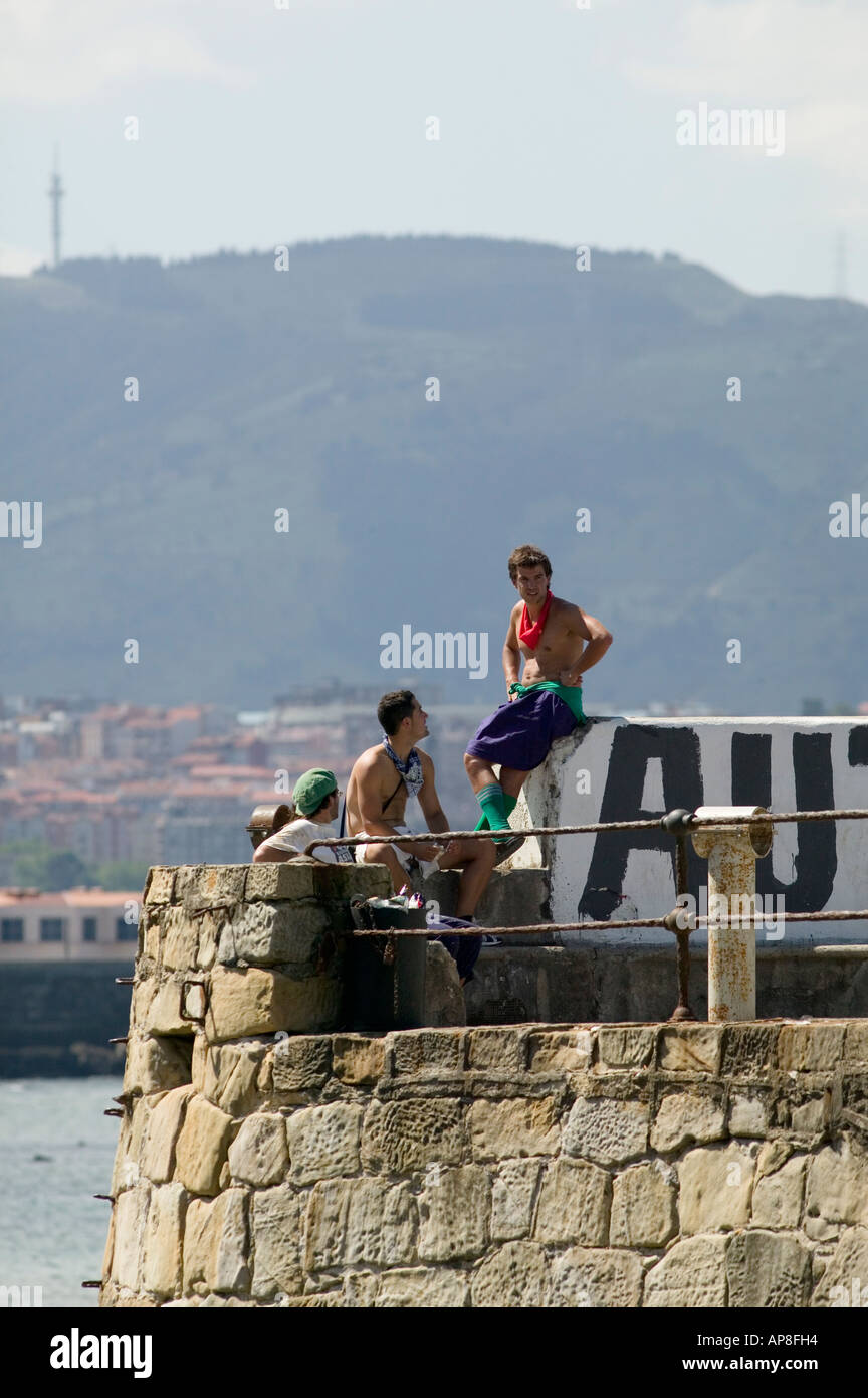Three Basque men sitting on harbour wall Puerto Viejo de Algorta Basque ...