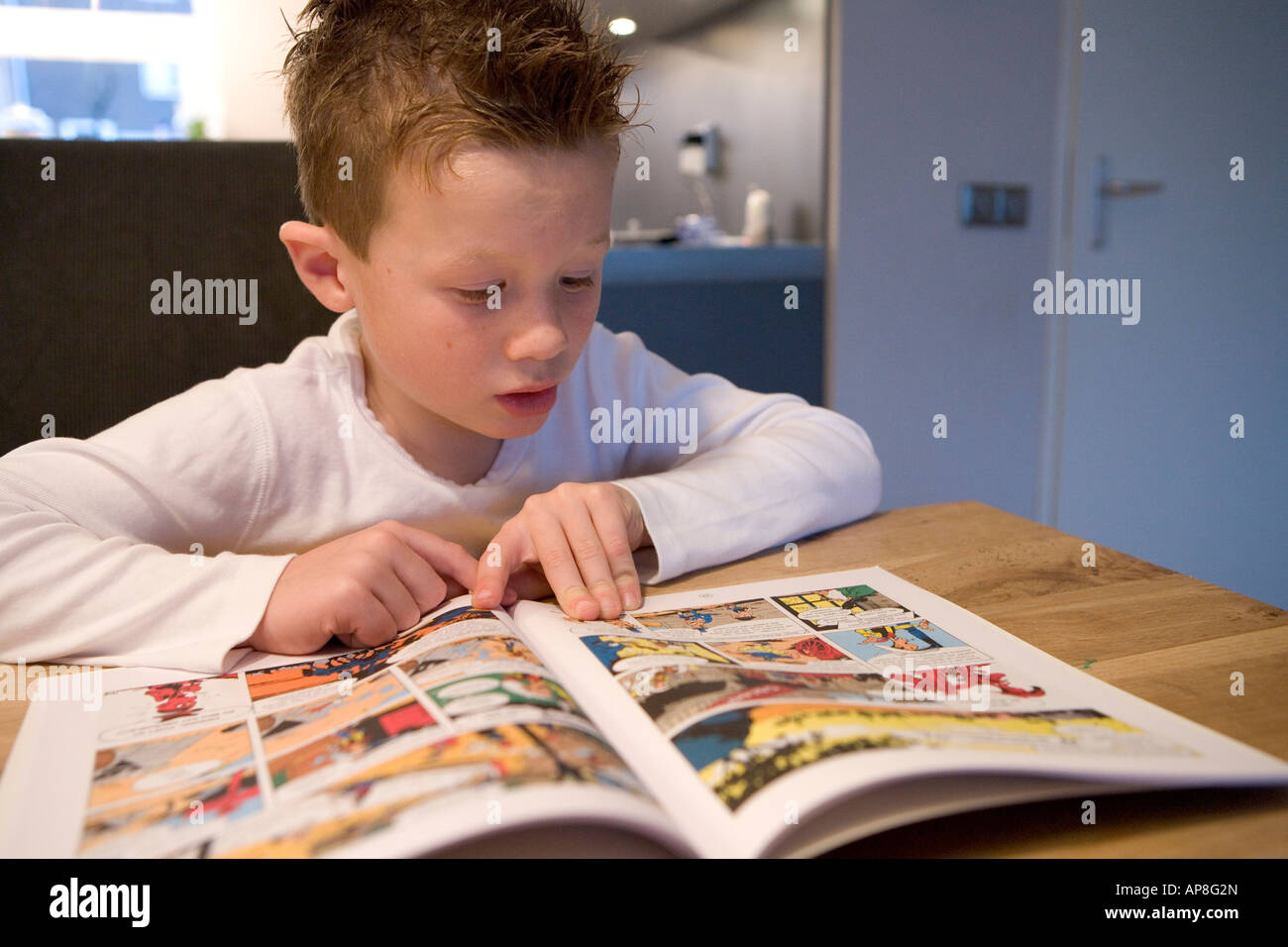 Boy is reading a comic Stock Photo - Alamy
