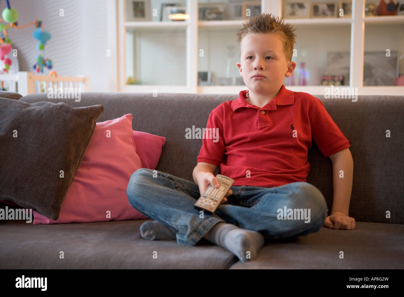 Boy with remote control in front of tv Stock Photo - Alamy