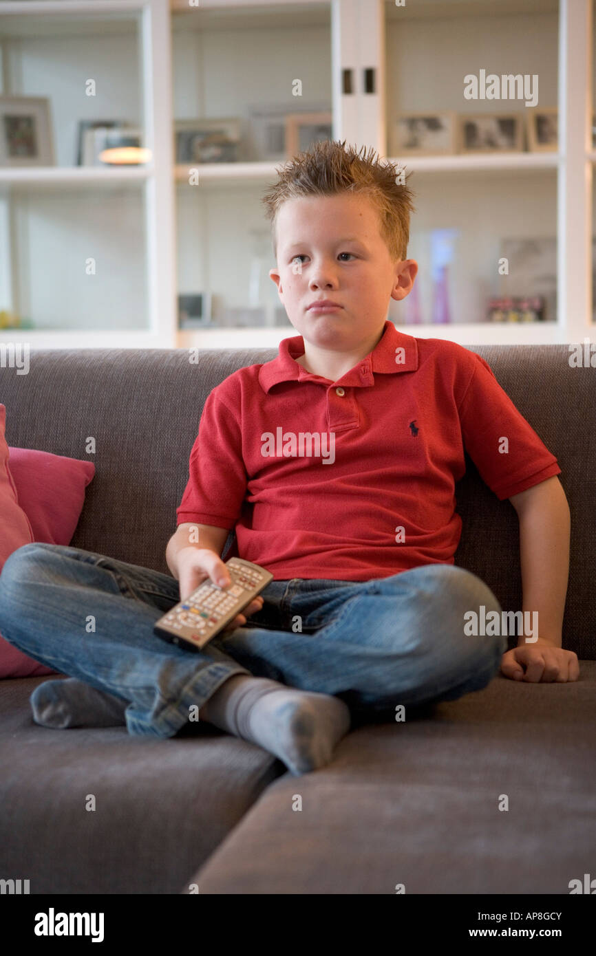 Boy with remote control in front of tv Stock Photo - Alamy