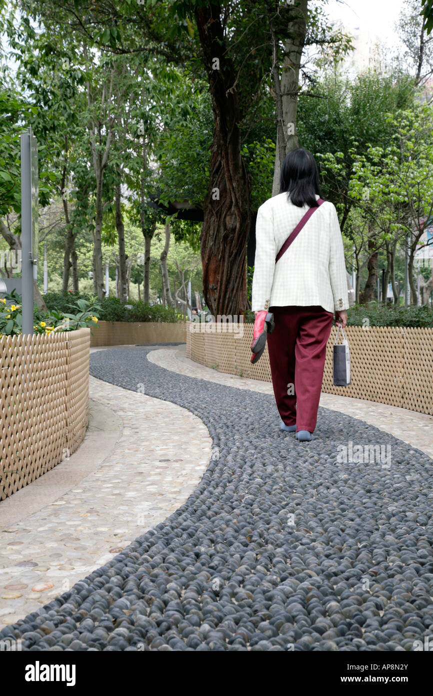 Woman walking on reflexology pebble pathway Stock Photo - Alamy
