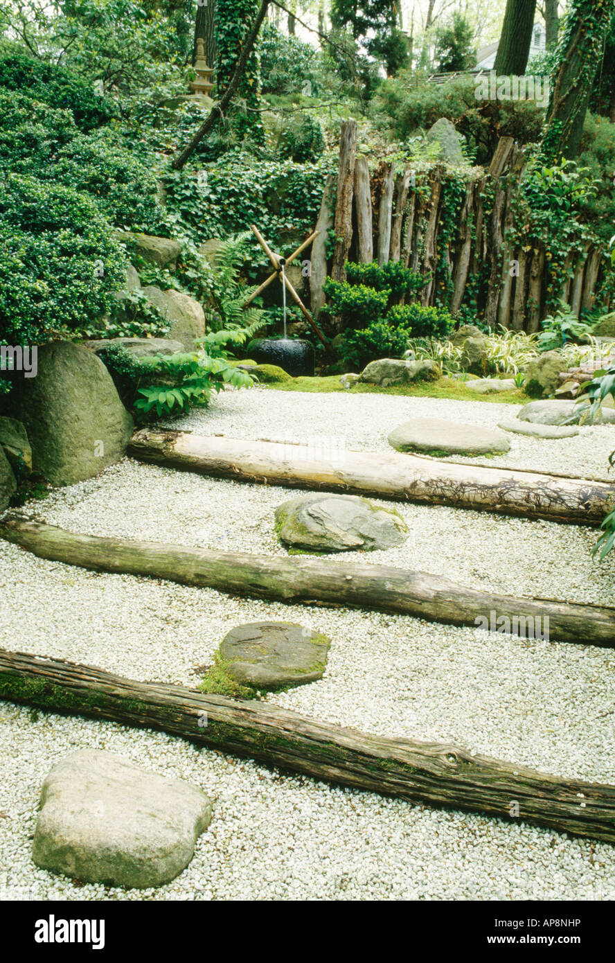 Stepping stones in gravel and log steps in oriental style garden Stock ...