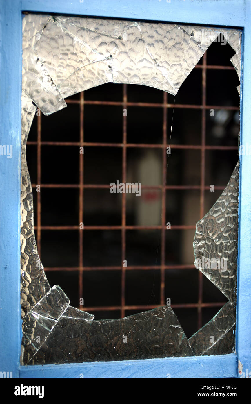 Urban decay: mesh guards an already broken window Stock Photo - Alamy