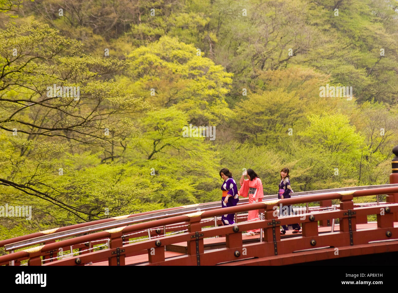 Japanese women in traditional clothes crossing the famous red bridge in ...