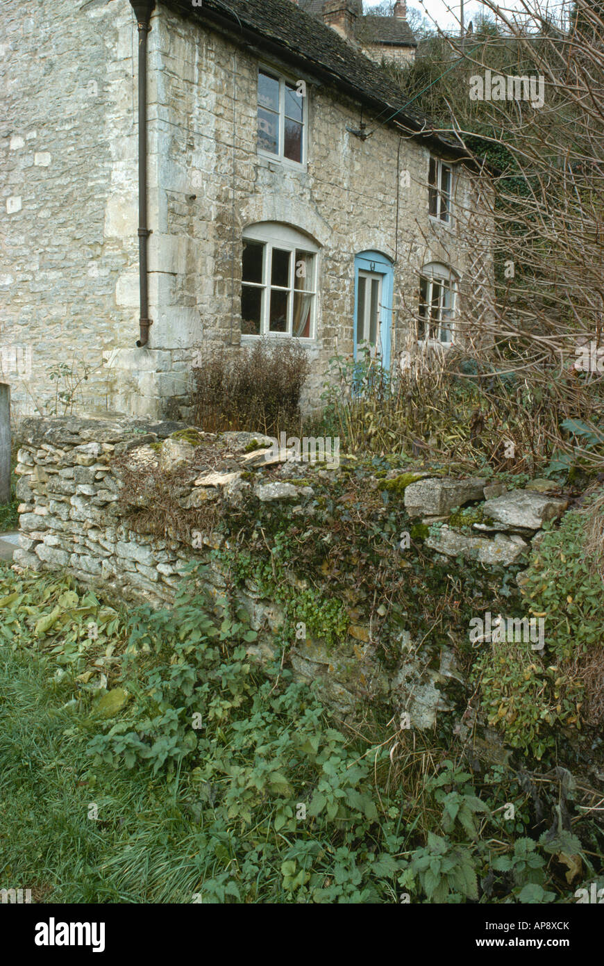 Dilapidated stone wall and sideways view of country cottage Stock Photo ...