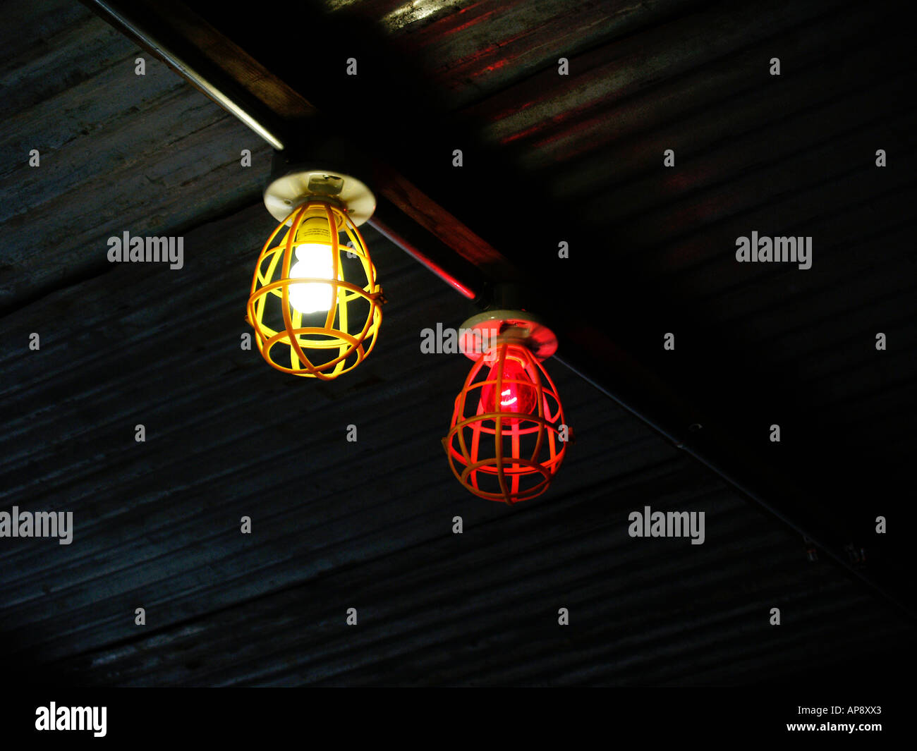 Red and yellow cage protected work lights in an urban construction area ...