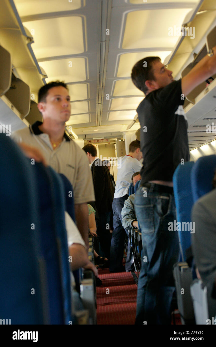 Passengers stowing luggage in overhead lockers Boeing 737 aircraft and ...