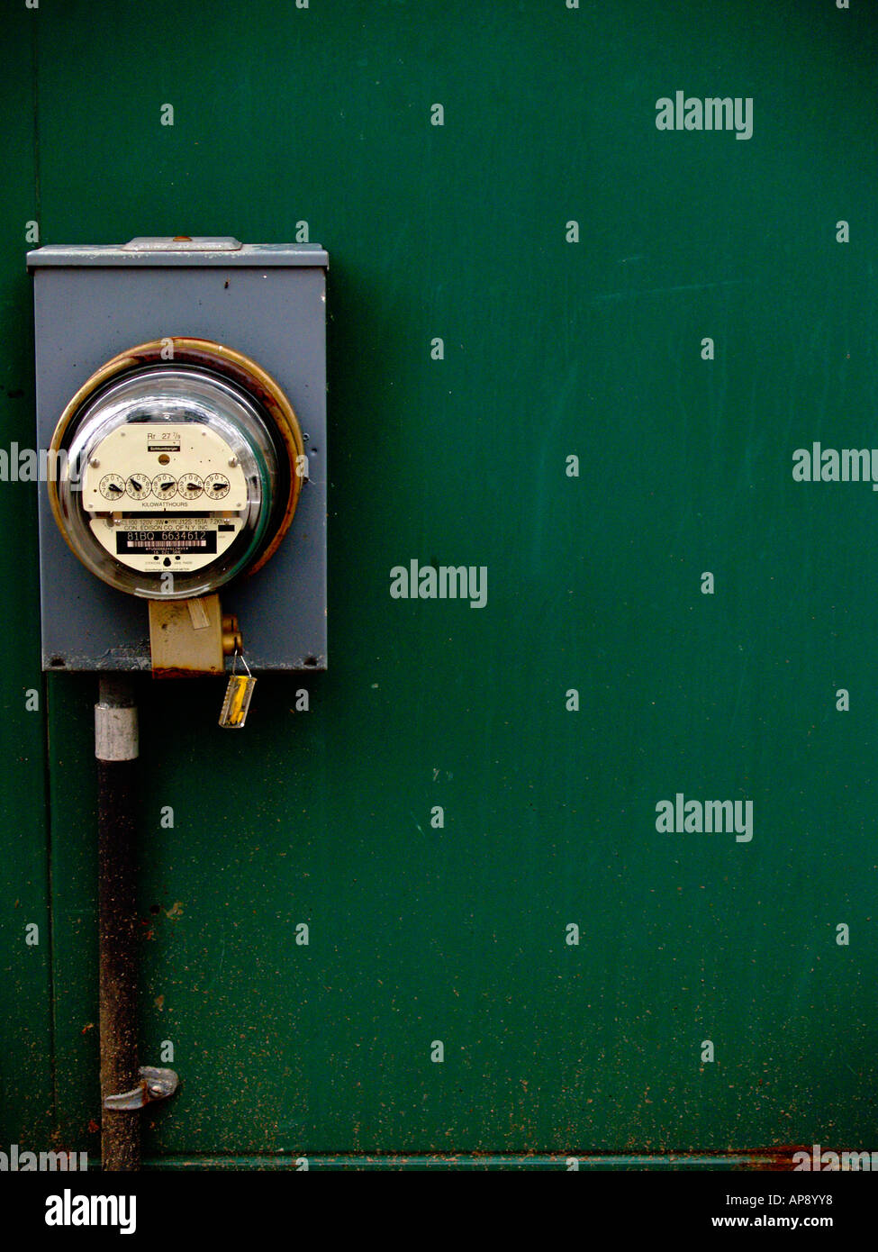 Outdoor electrical power meter at left side of frame on blue-green wall ...