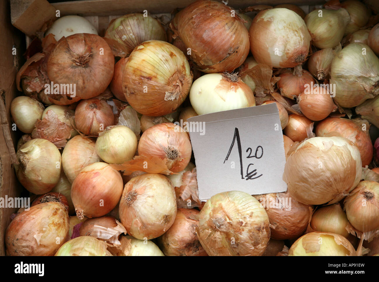 Heap of onions with a price label 1.20 euro on the street vegetable ...