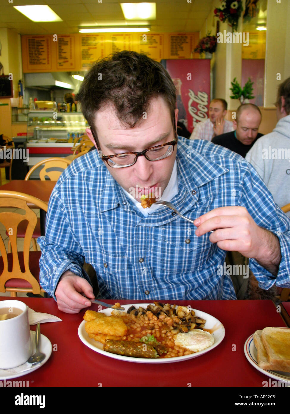 Man eating traditional English breakfast with vegetarian sausage London ...