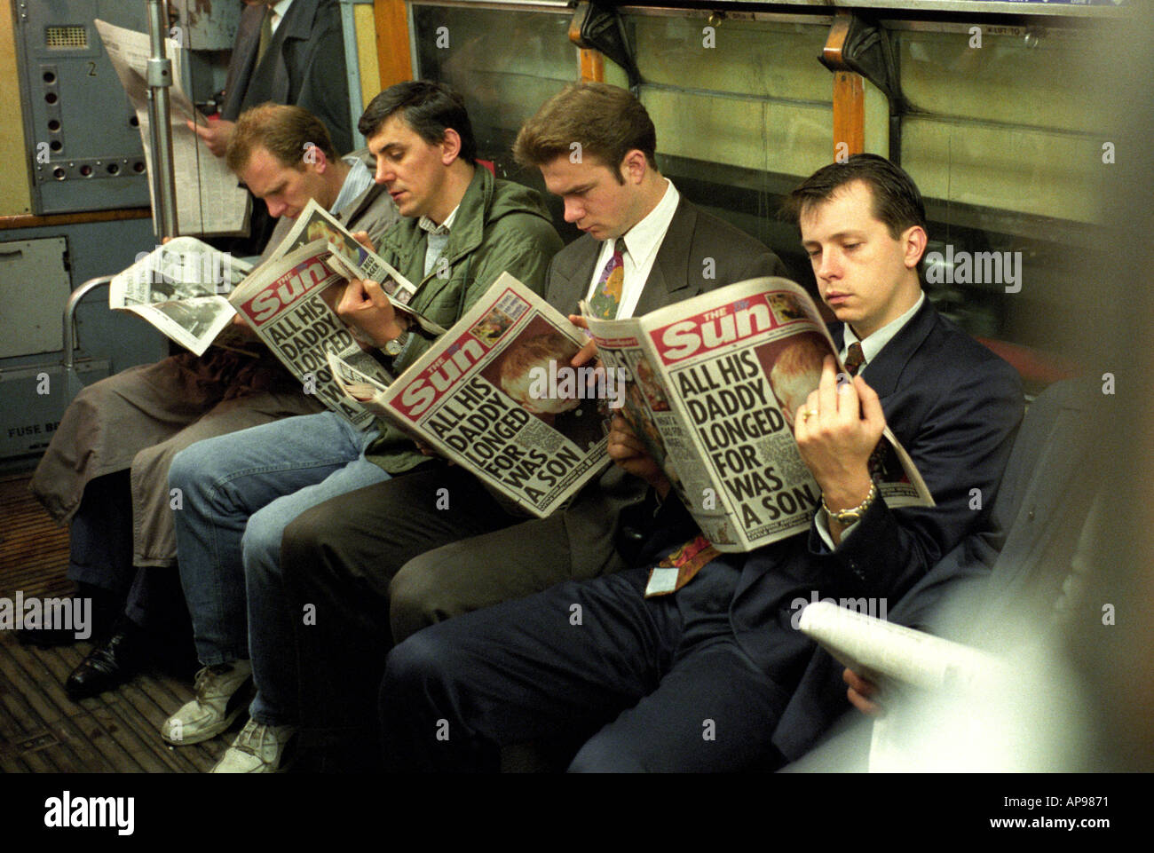 Men reading the sun newspaper on the tube train in London Stock Photo ...