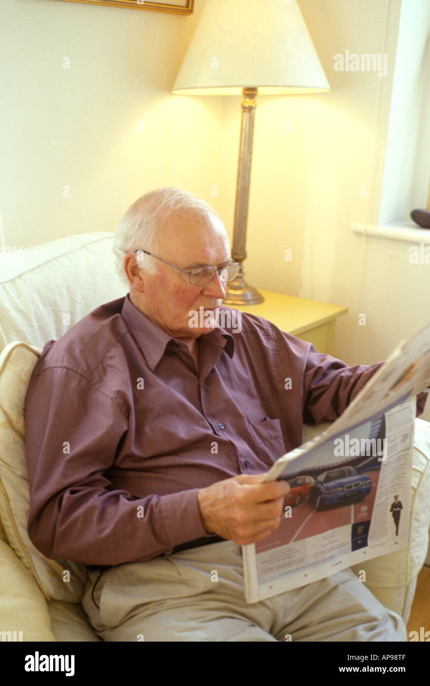 old man reading newspaper by lamp light Stock Photo - Alamy