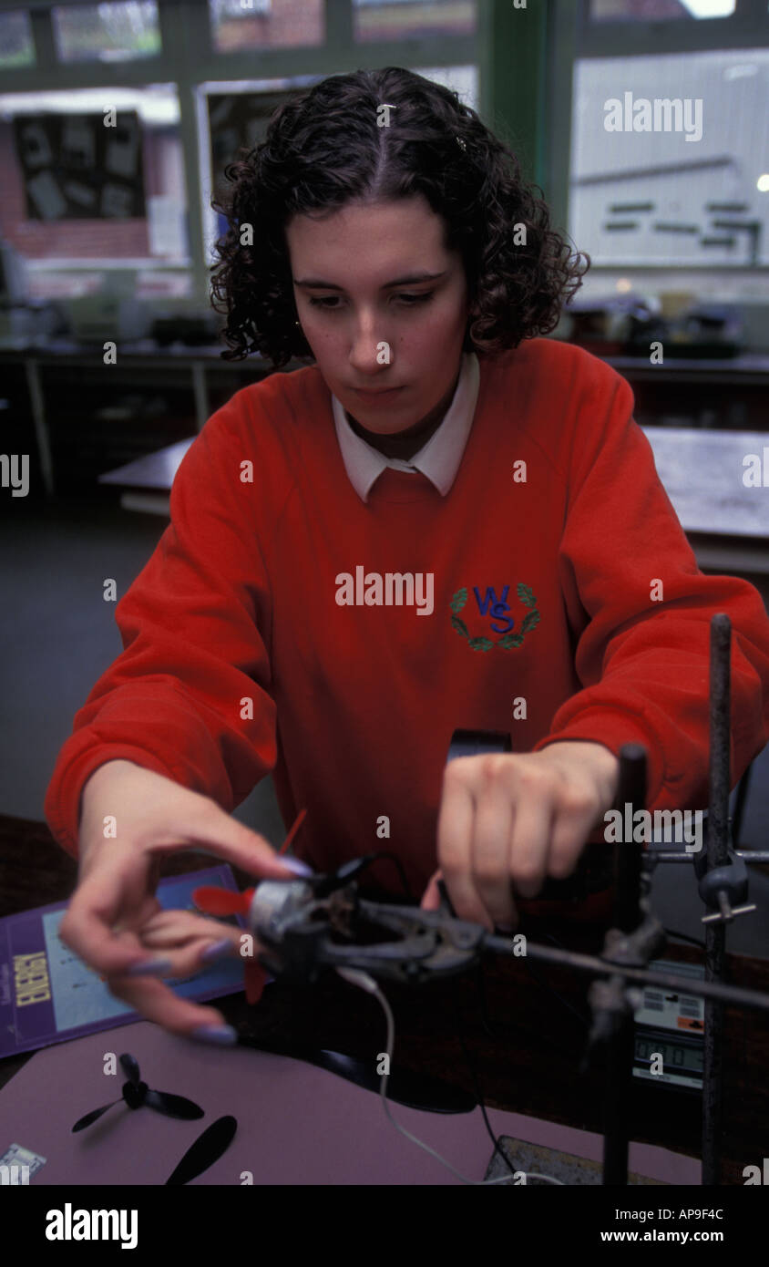 Secondary school girl pupil undertaking experiment in science lab ...