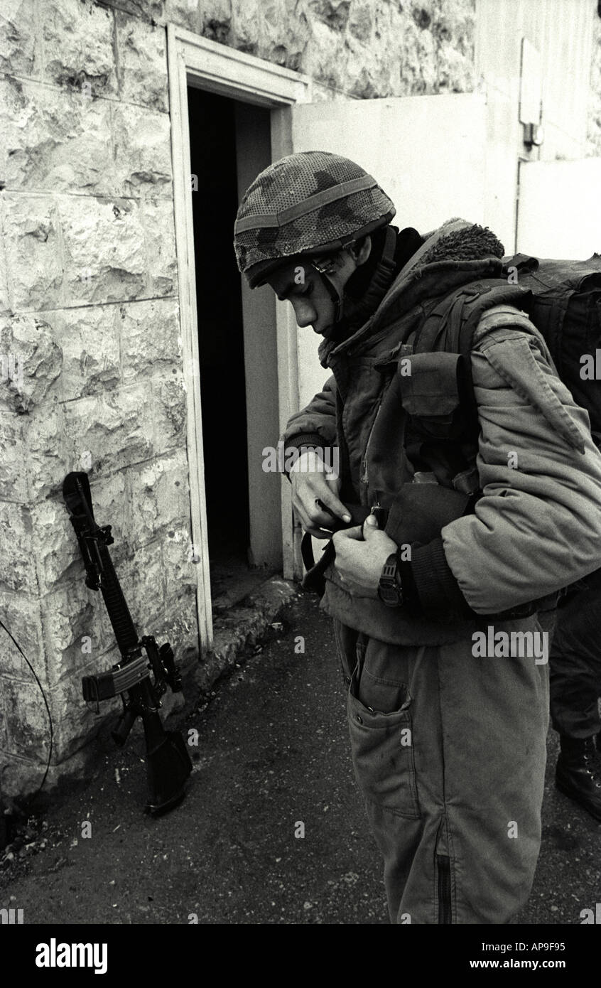 IDF soldier adjusting his kit prior to patrolling the streets of Hebron ...