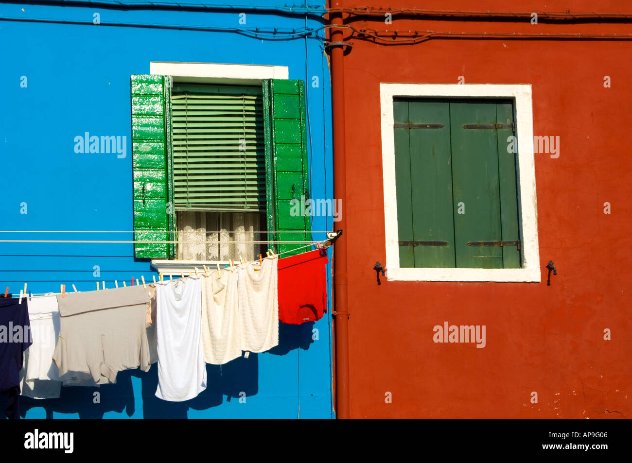 Two colorful homes with green windows and a clothesline Stock Photo - Alamy