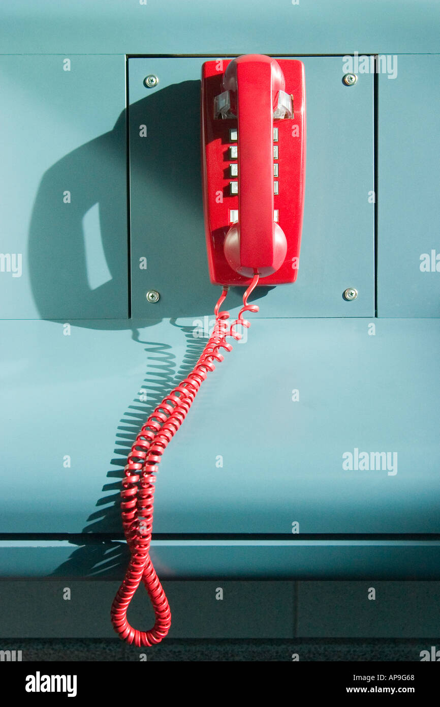 A graphic image of a bright red telephone and its shadow on a blue ...