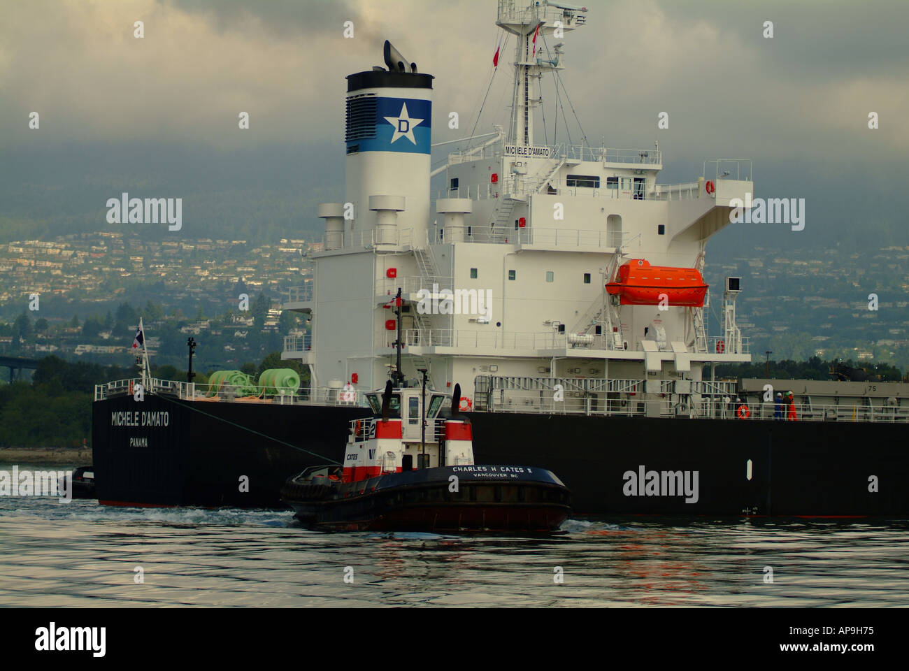 Tug boats turning large cargo ship around in a Vancouver port Stock ...