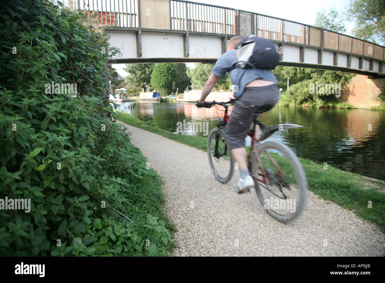 cyclist riding a bike next to a canal Stock Photo - Alamy