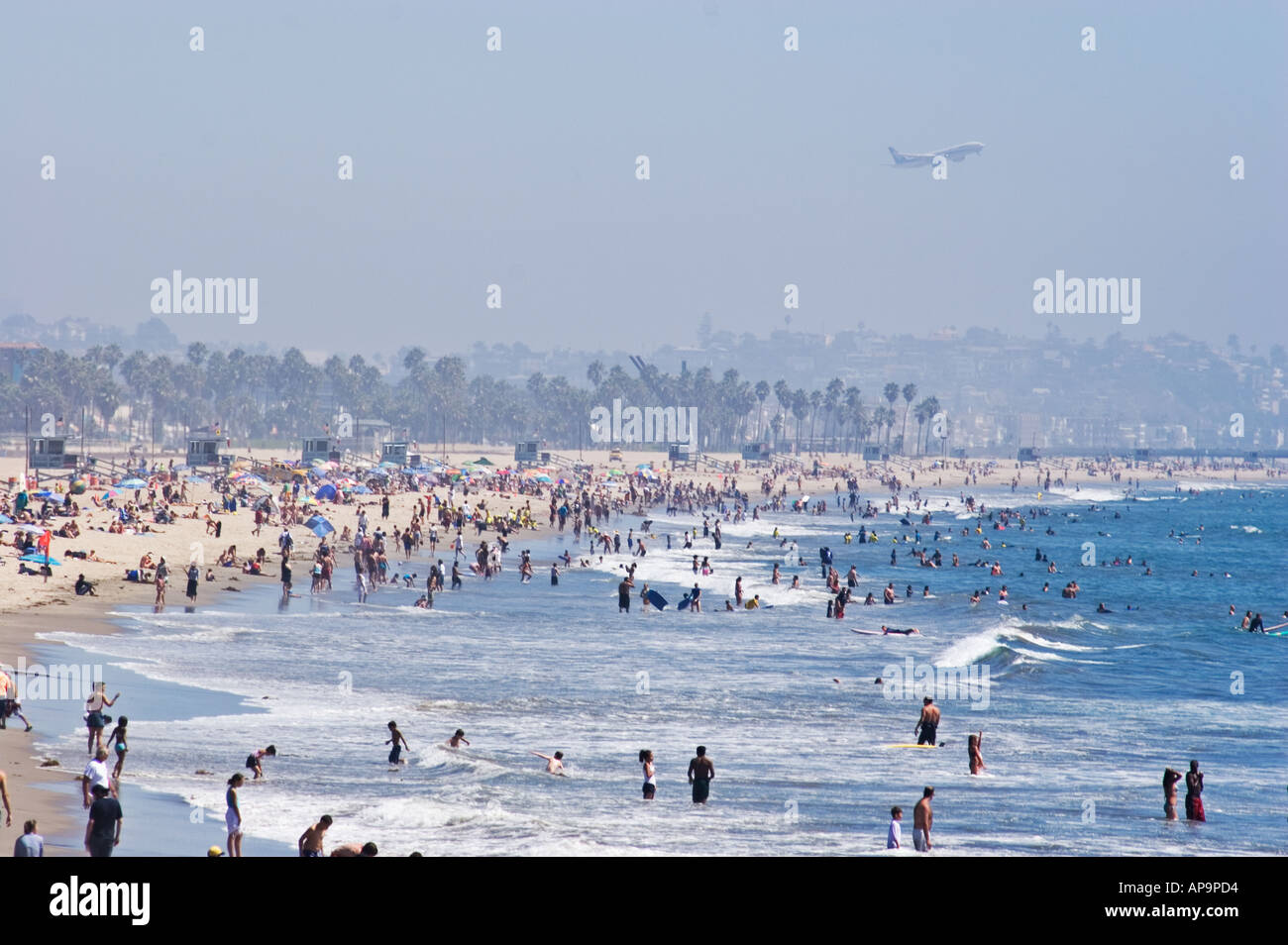 Jet flying over a crowded beach Stock Photo - Alamy