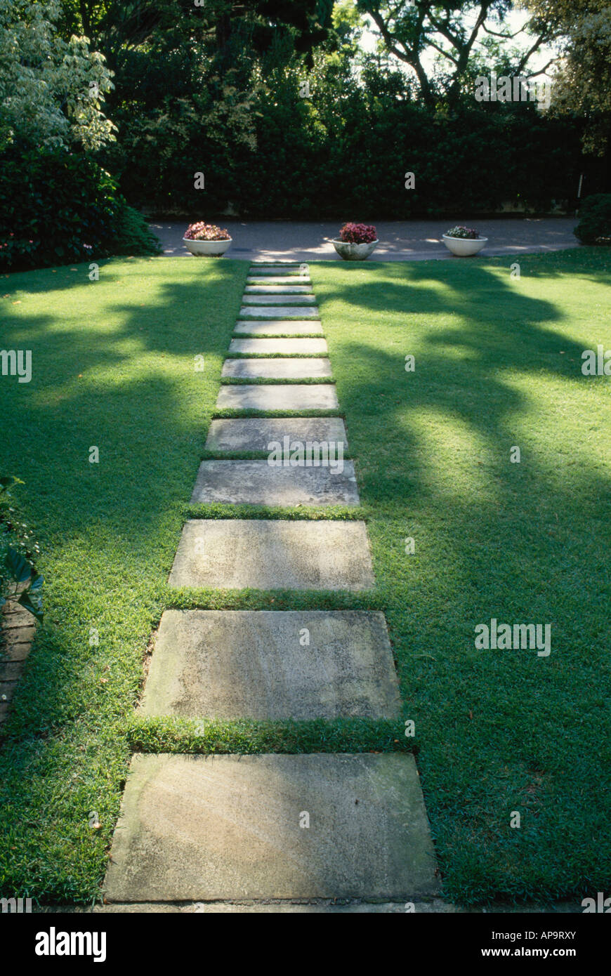 Straight paved path across sunlit lawn in country garden Stock Photo ...