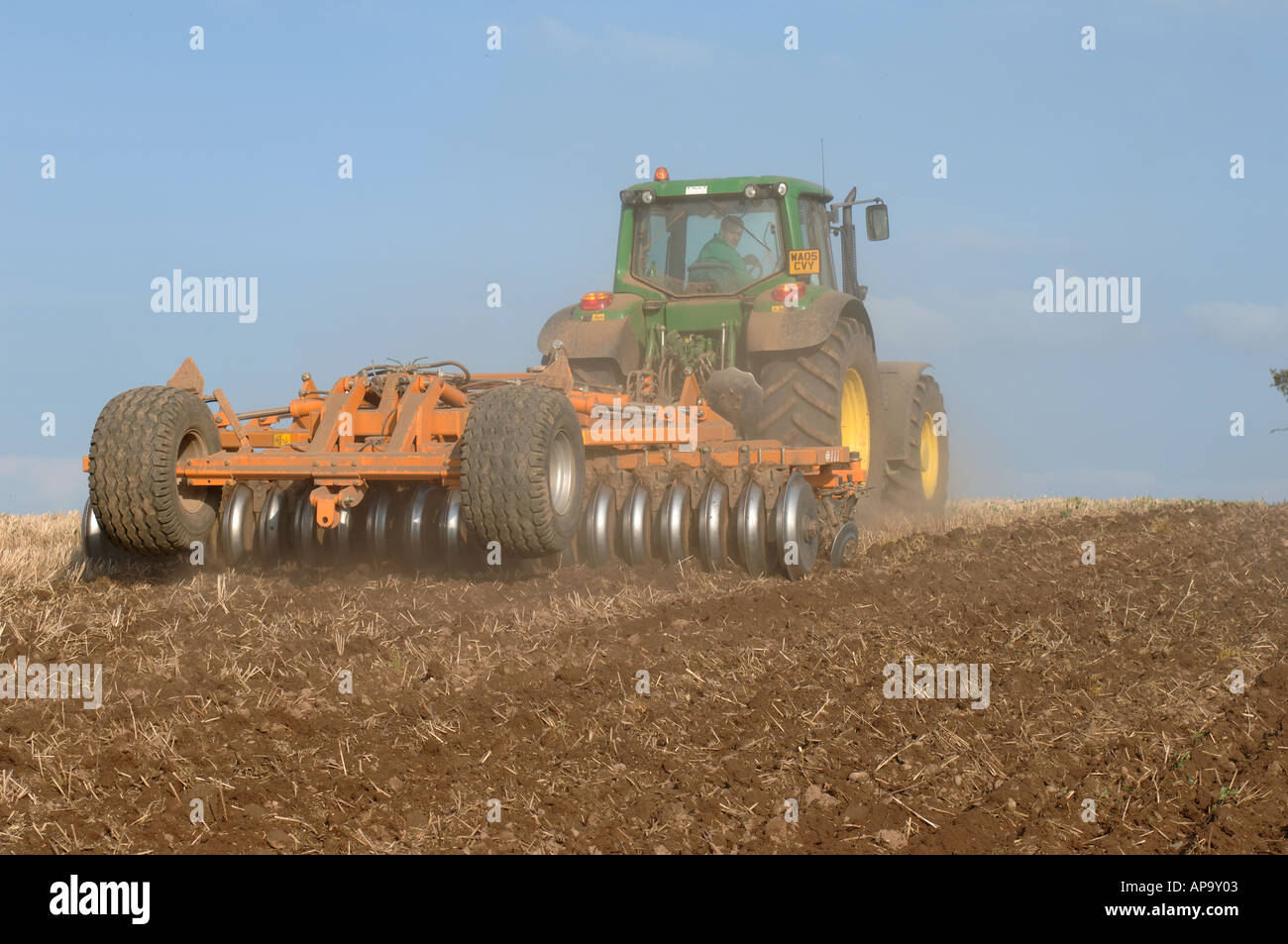 John Deere tractor power disc harrowing subsoiled stubble field before ...