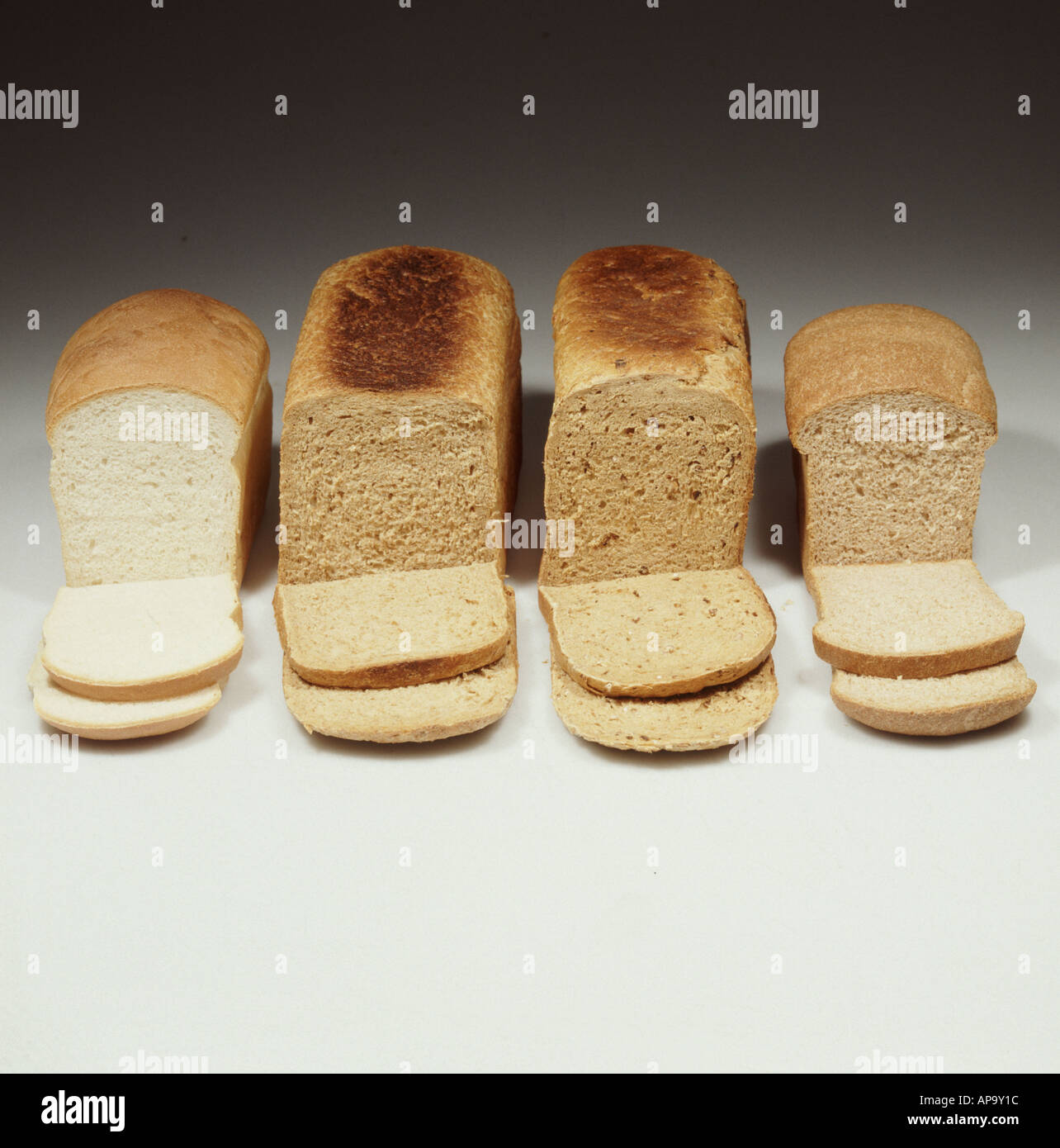 Various loaves of breads sliced on plain background from left White ...