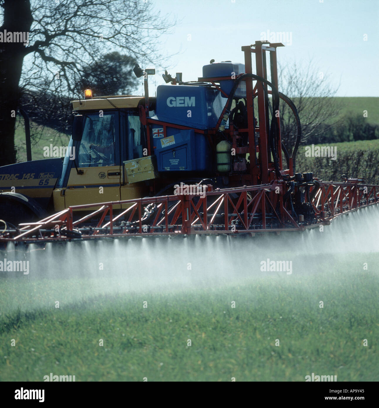 Fastrac tractor and mounted Gem sprayer spraying young barley crop in ...