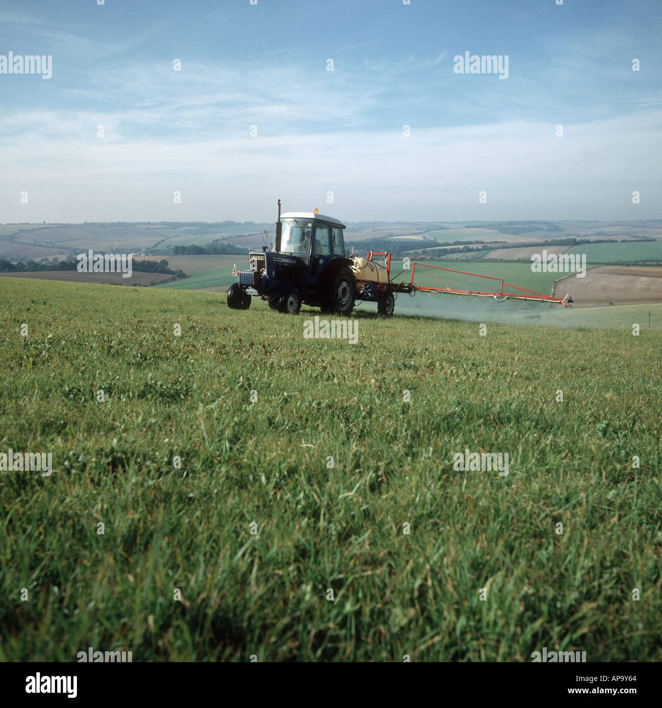 Old Ford tractor and boom sprayer spraying grass ley for renovation in ...