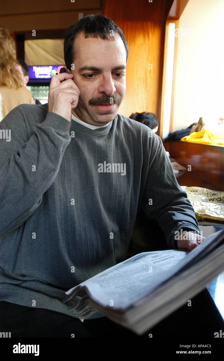 A man looking for a job in the Classified section of the newspaper ...