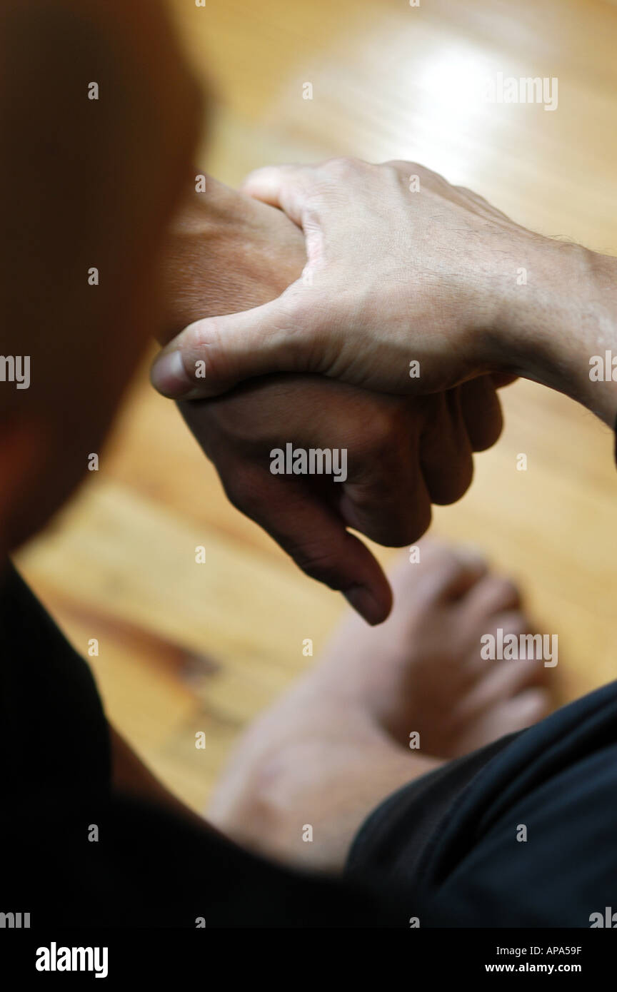 From above over right shoulder clasped hands foot below wood floor ...