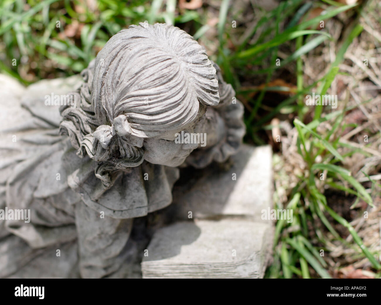 Stone statue of girl reading a book while lying down in a church ...