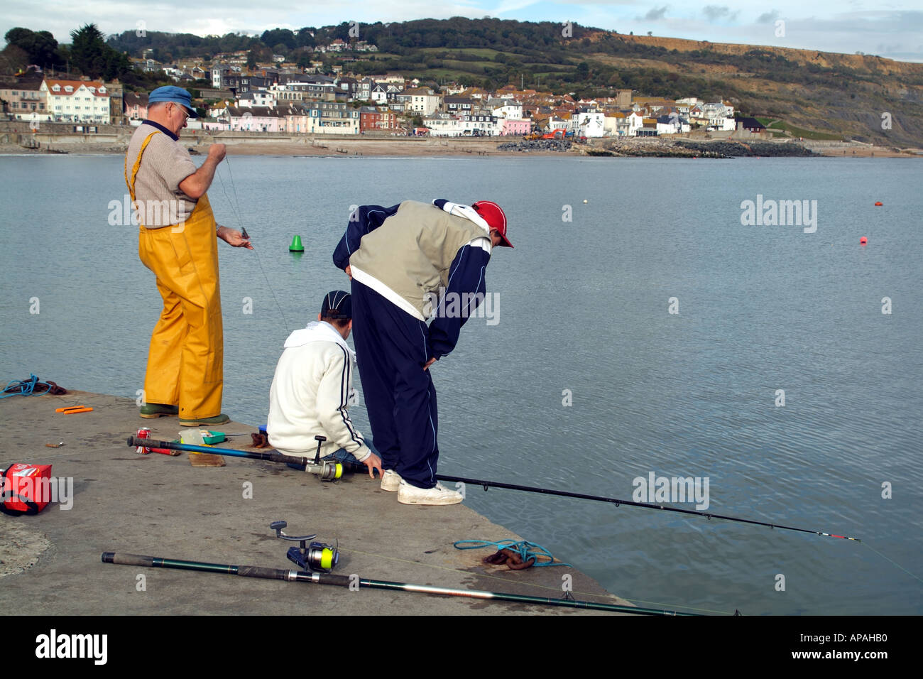 Young and old fishing off The Cobb at Lyme Regis Dorset southern ...