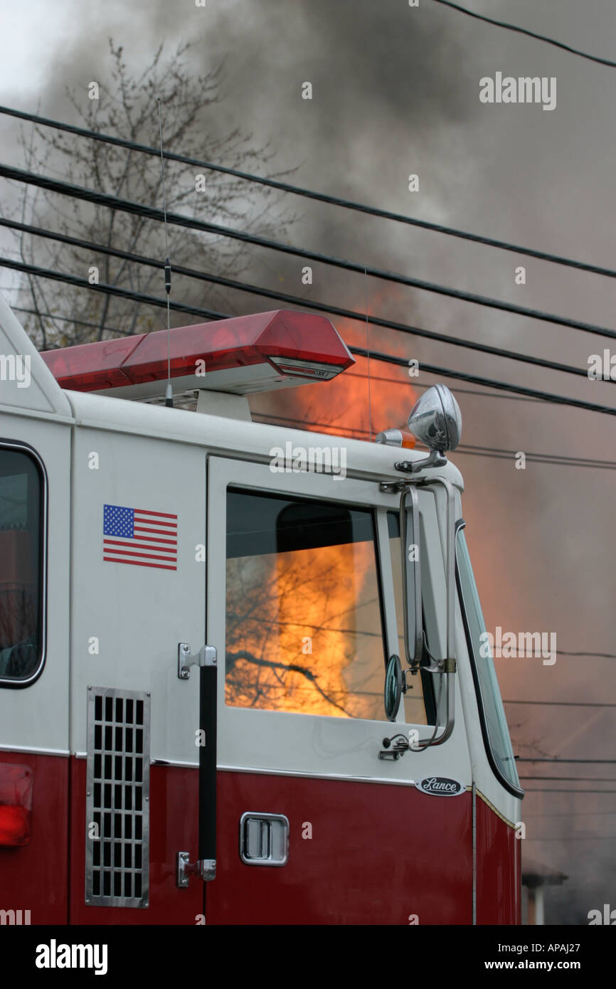 Fire engine with fire in background Stock Photo - Alamy