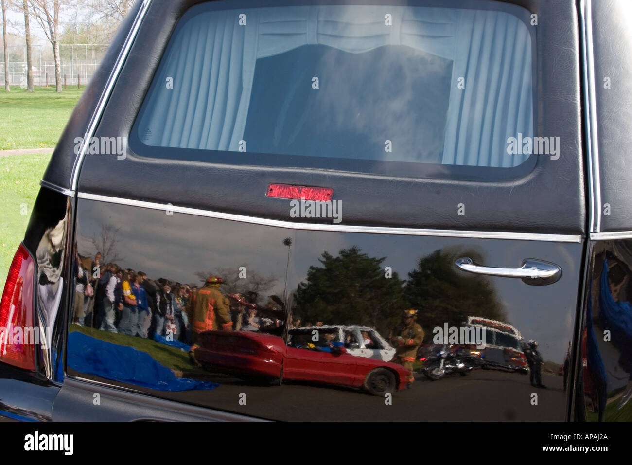 Grim reflections of people in the back door of a hearse staged ...