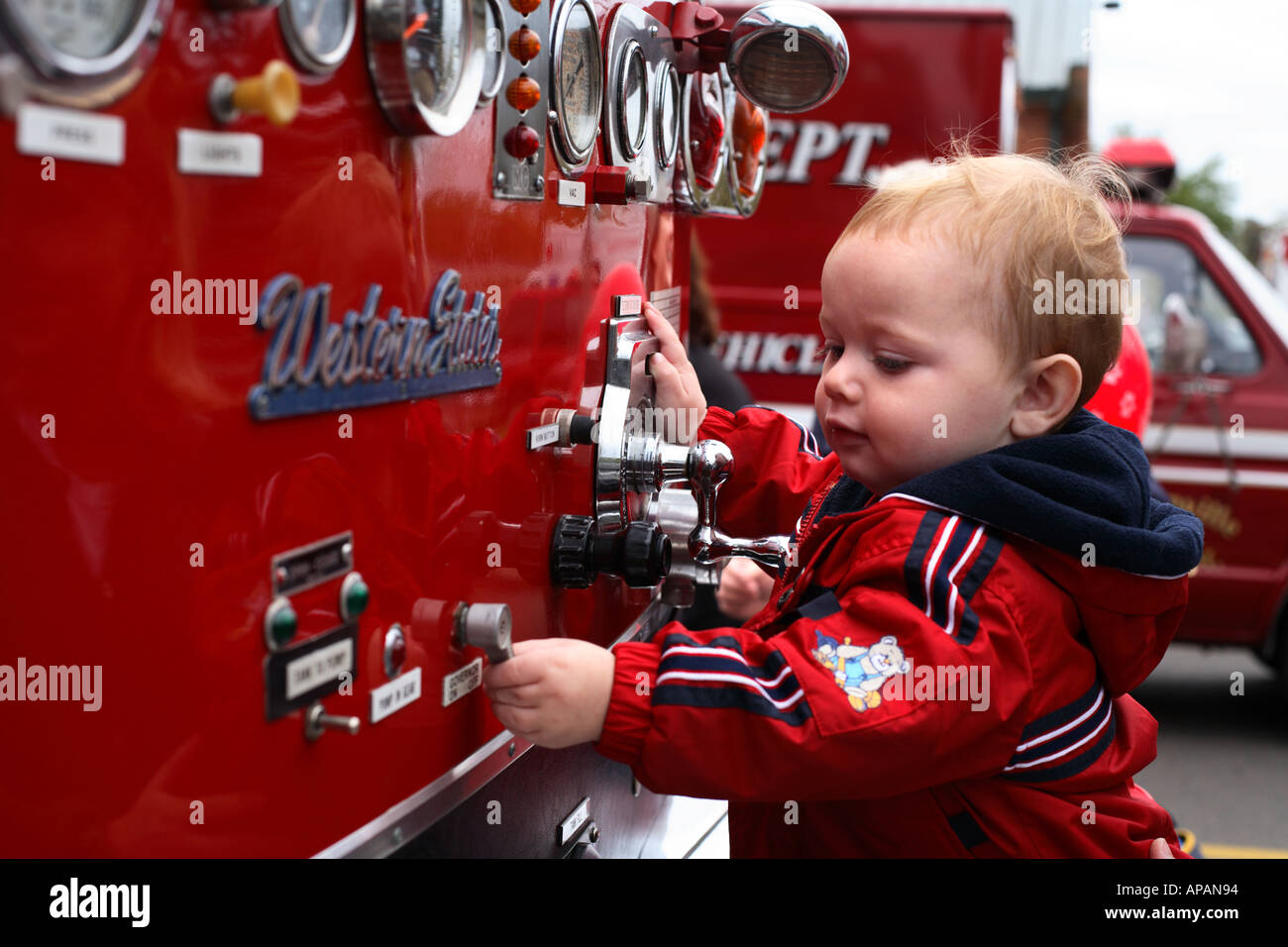 Toddler playing with controls on fire truck Stock Photo - Alamy