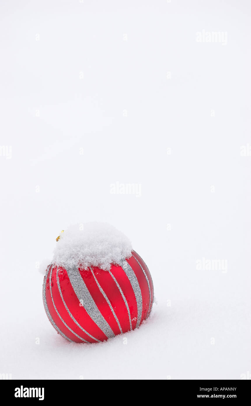 Close up of red Christmas bauble in snow Stock Photo - Alamy