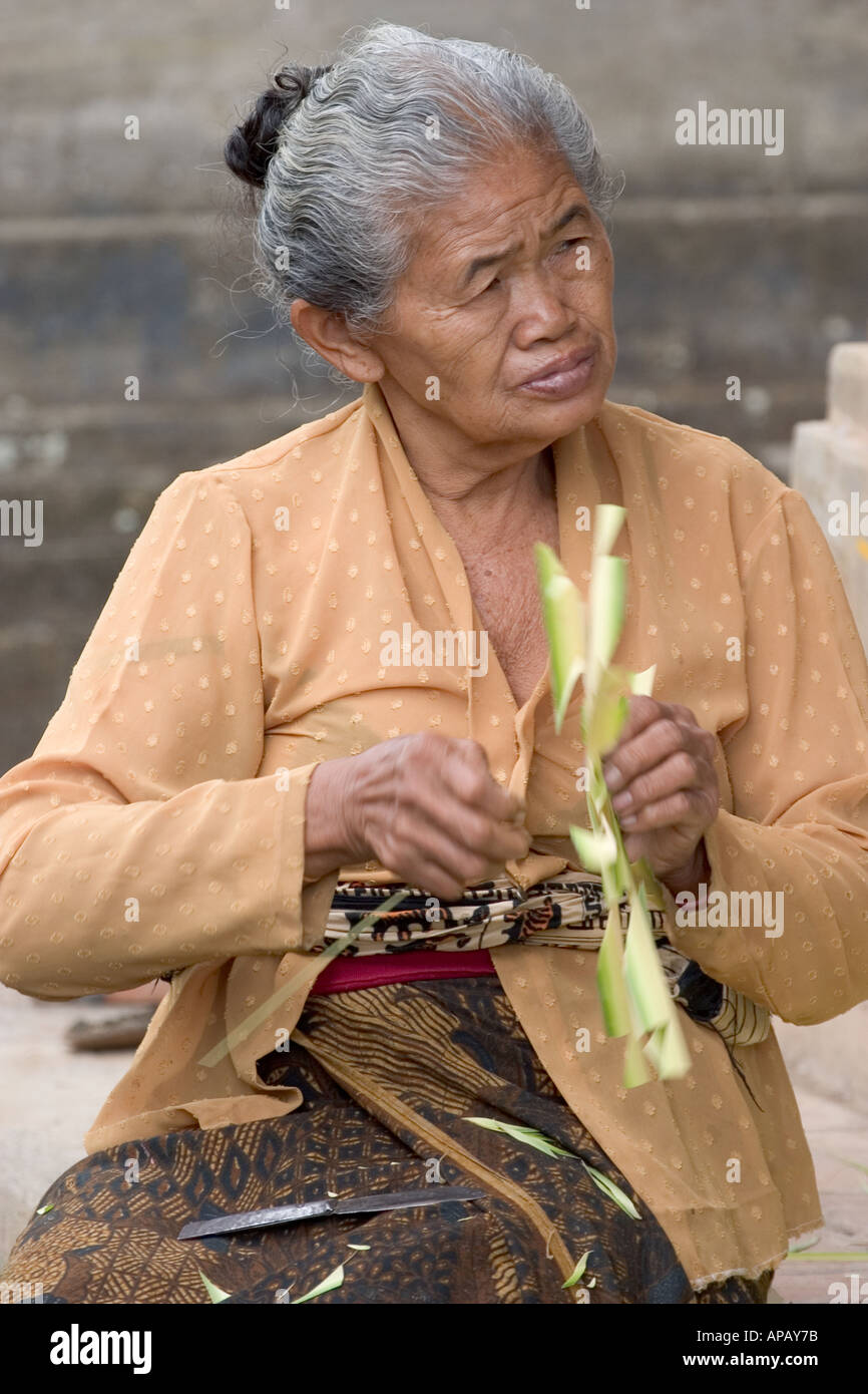 Balinese Lady weaving basket in Temple Stock Photo - Alamy
