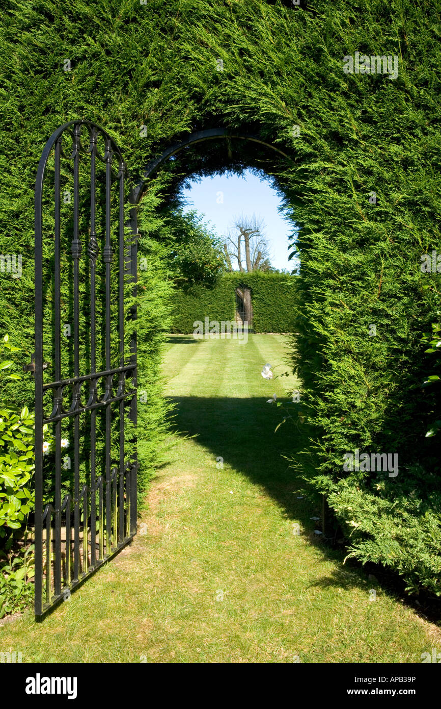 UK gardens. Gate through clipped hedge with view to lawn beyond Stock ...