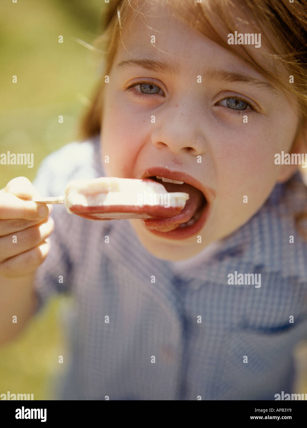 A school girl eating an ice lolly shot from above Stock Photo - Alamy