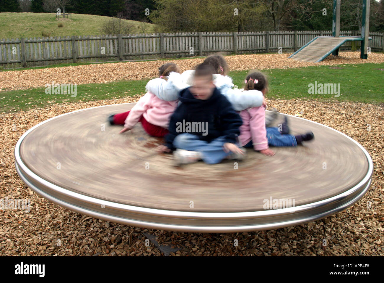 Group of children spinning on roundabout Stock Photo - Alamy