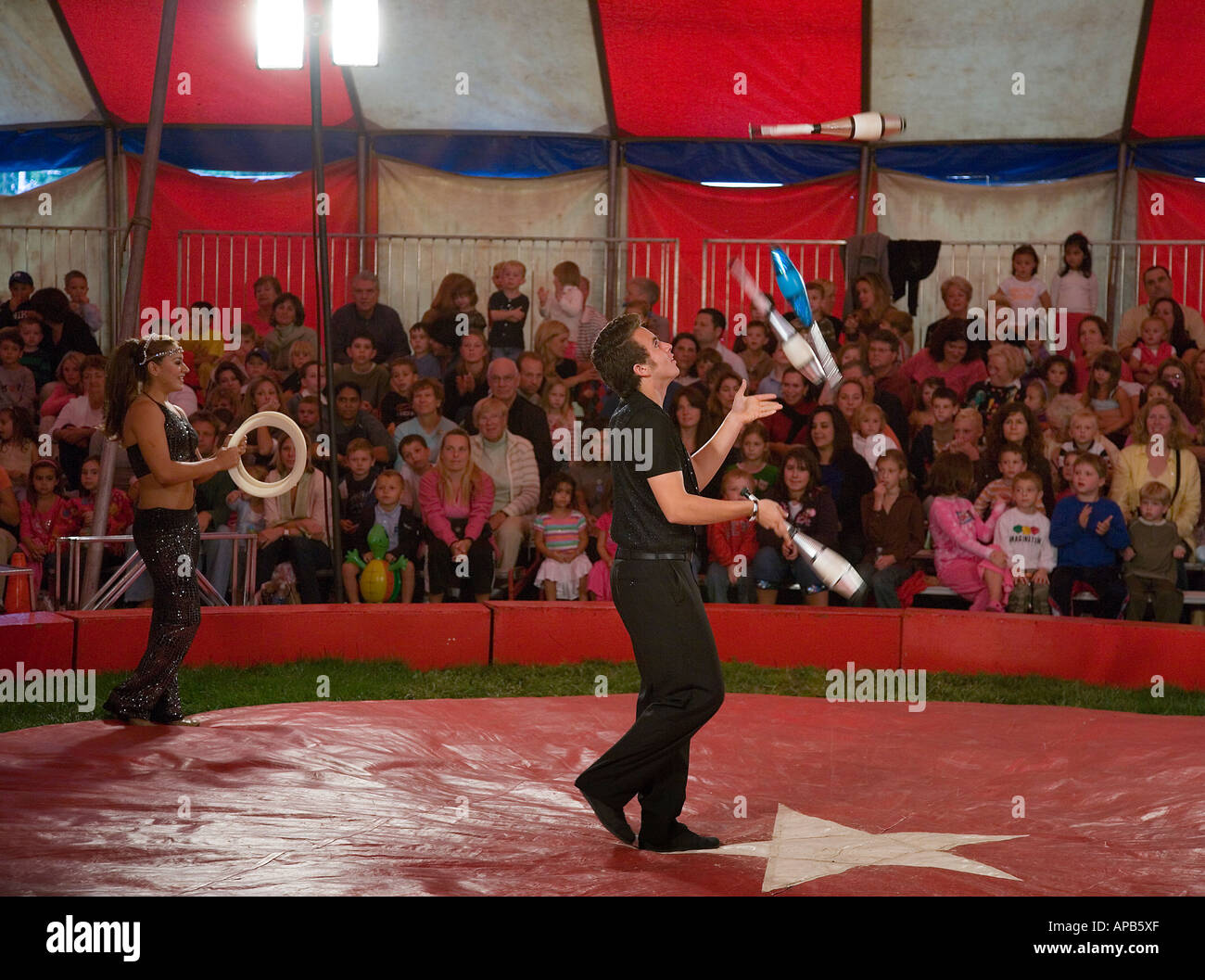 Circus performer juggling while the audience watches Stock Photo - Alamy